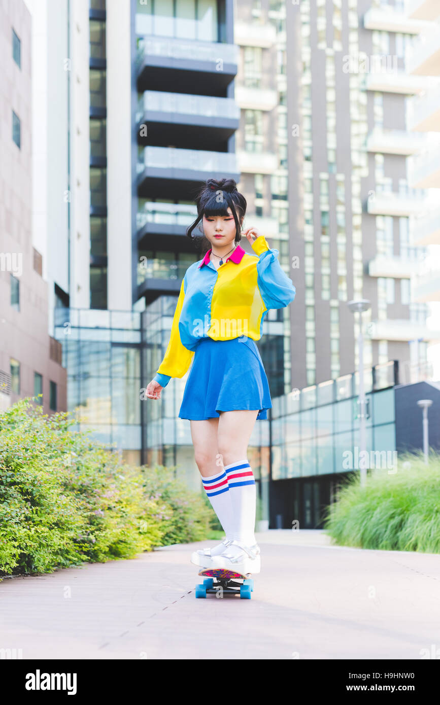 young beautiful asian millennial woman nonconformist skating outdoor in the city - skater ...
