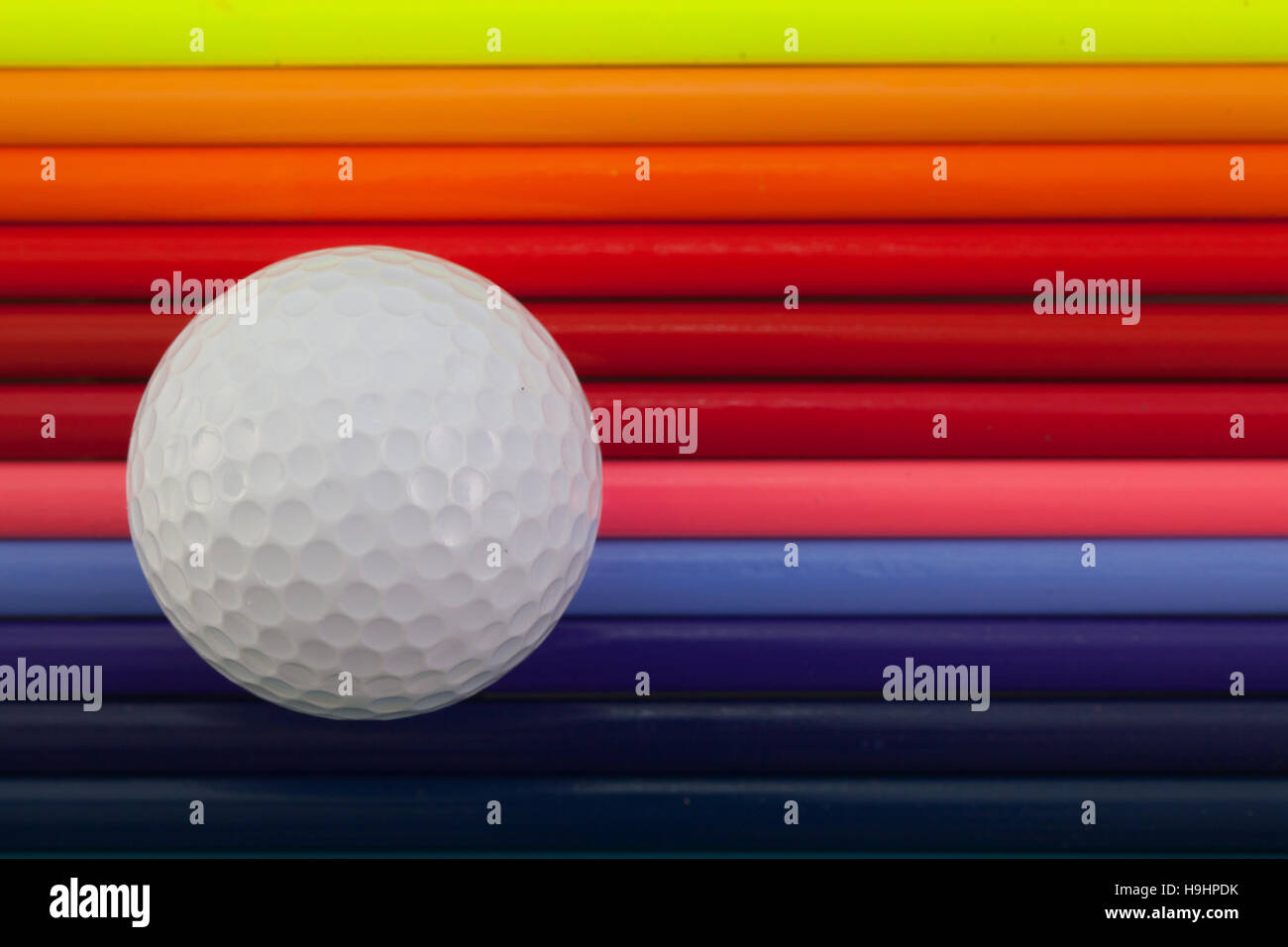 Detail of rainbow colorful pencil and golf ball on the table Stock ...