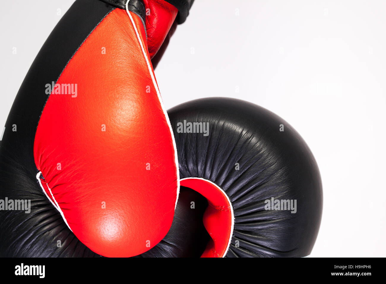 Red and black boxing gloves on a glass table isolated on white ...