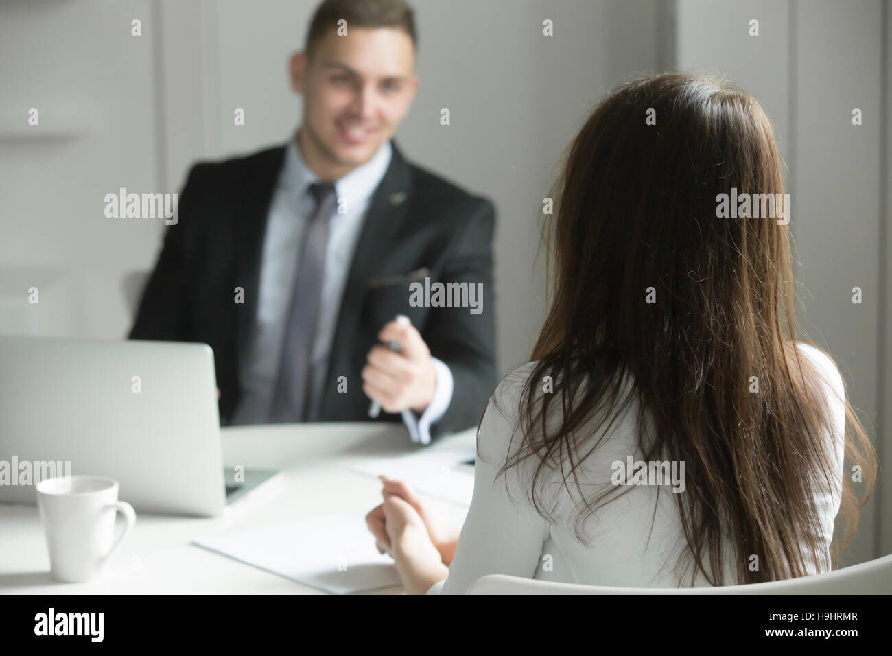 Two business people talking at the office desk Stock Photo - Alamy