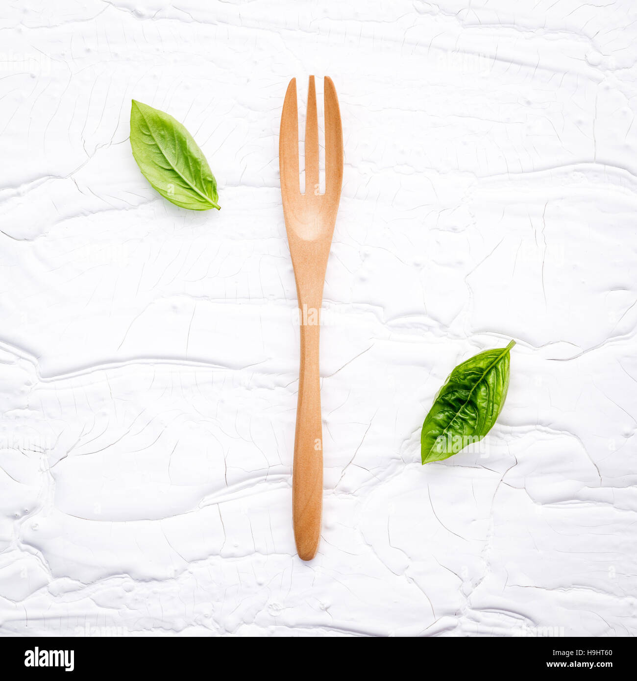 Closeup fresh sweet basil leaves with fork on white wooden bac Stock ...