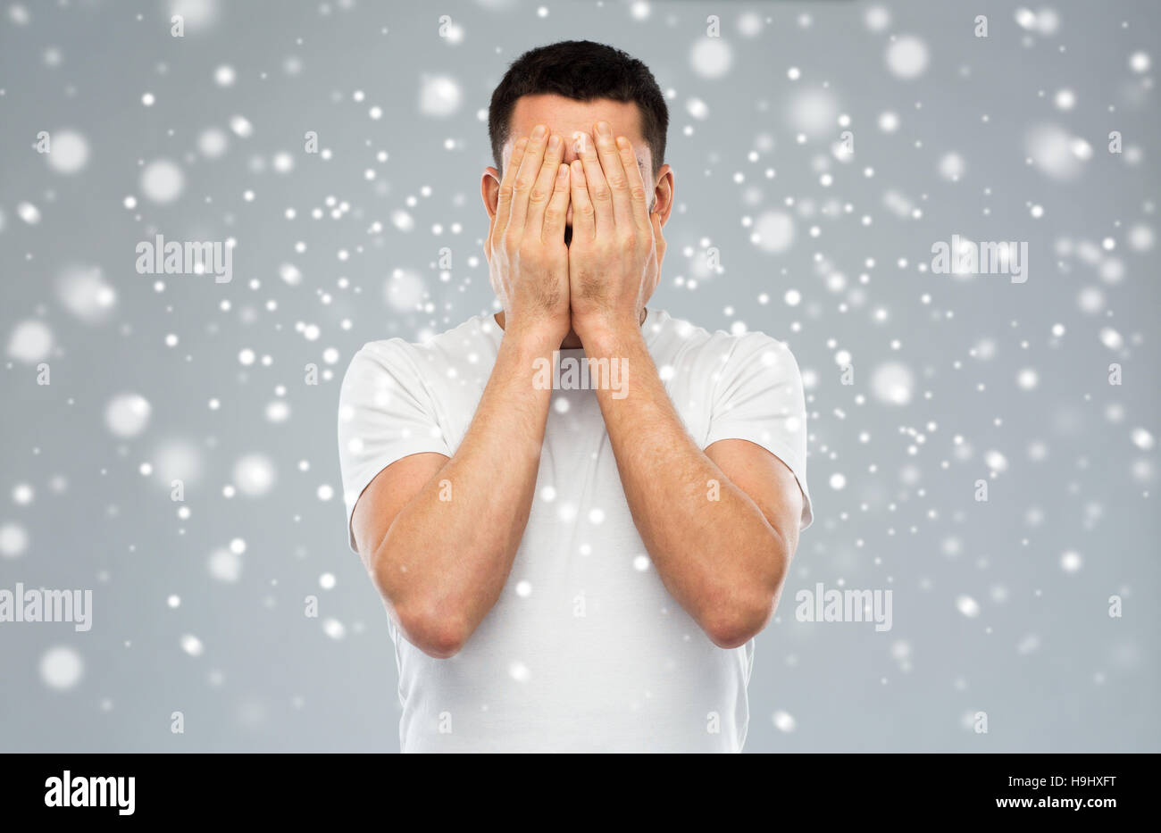 man covering his face with hands over snow Stock Photo - Alamy
