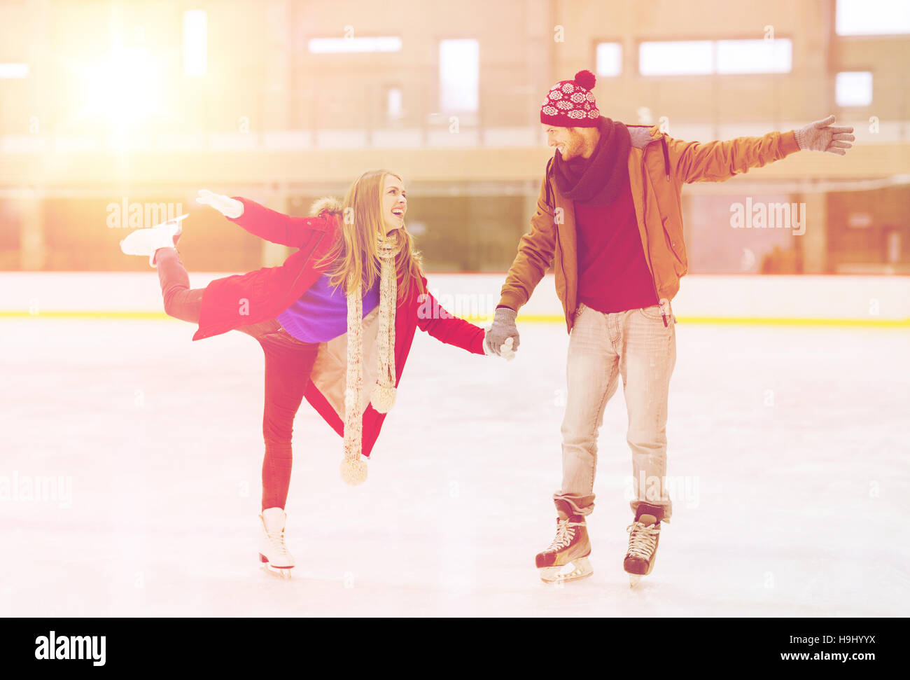 happy couple holding hands on skating rink Stock Photo - Alamy