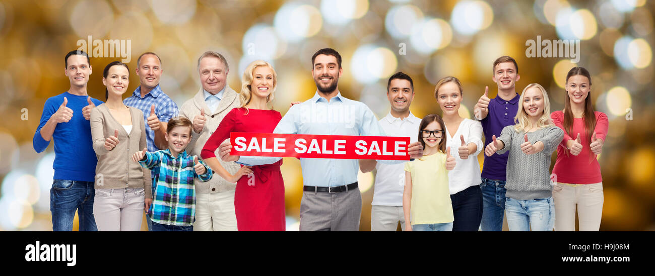 happy people with sale sign showing thumbs up Stock Photo - Alamy
