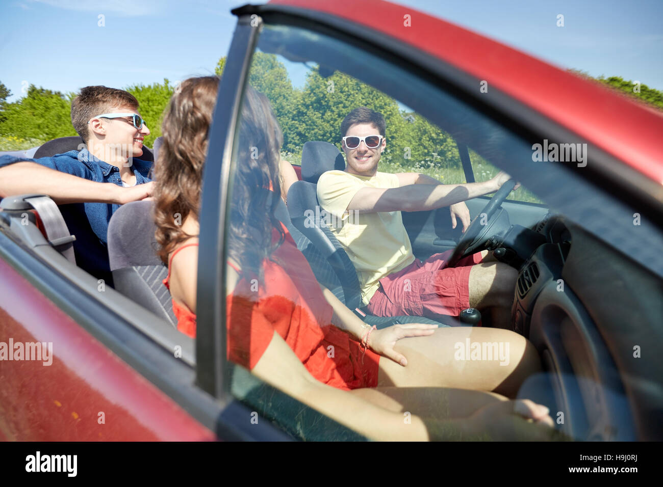 happy friends driving in cabriolet car and talking Stock Photo - Alamy