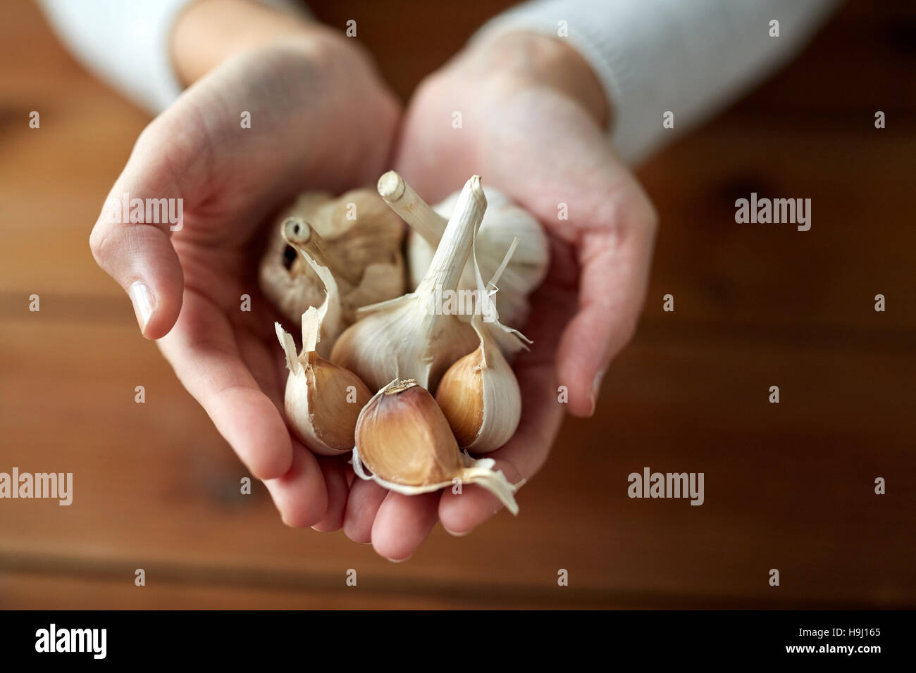 woman hands holding garlic Stock Photo - Alamy