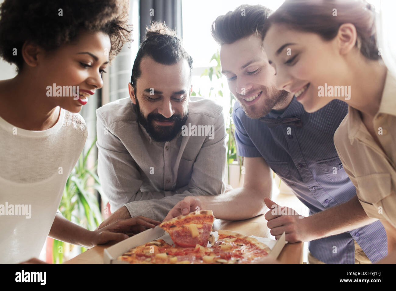 happy business team eating pizza in office Stock Photo - Alamy