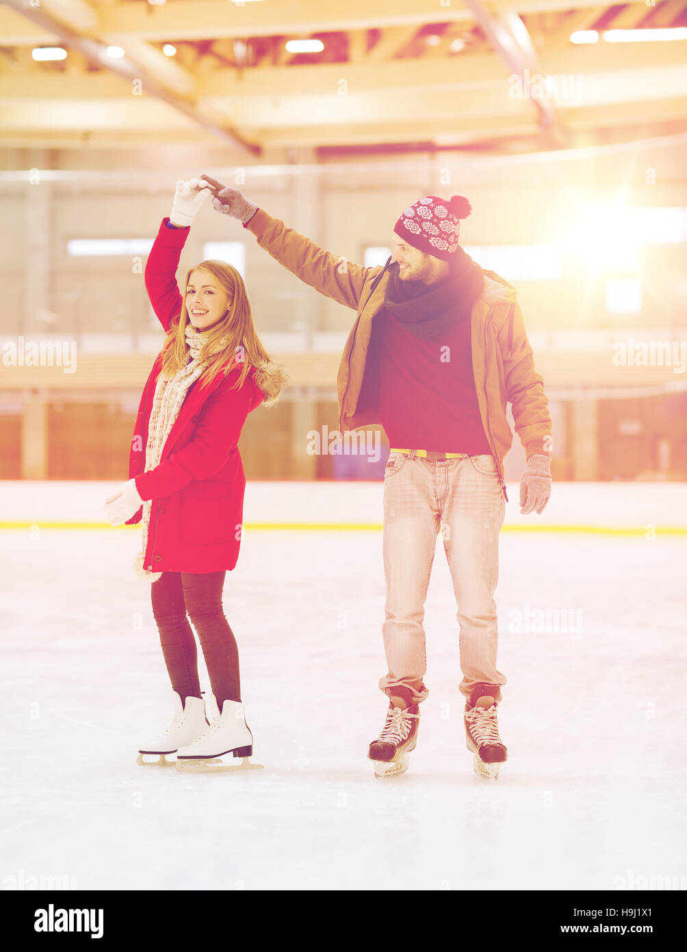 happy couple holding hands on skating rink Stock Photo - Alamy