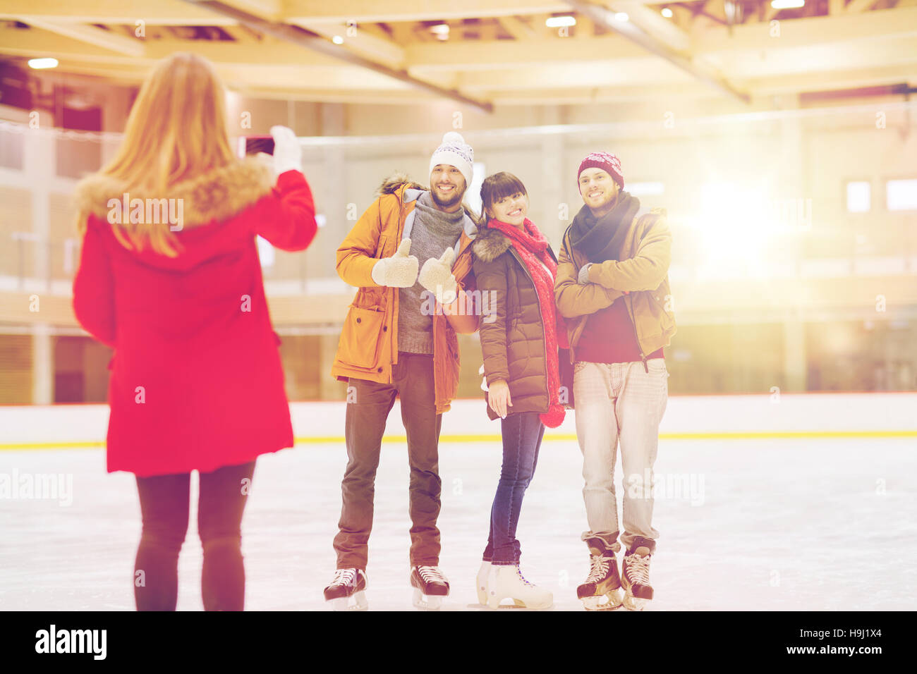 happy friends taking photo on skating rink Stock Photo - Alamy