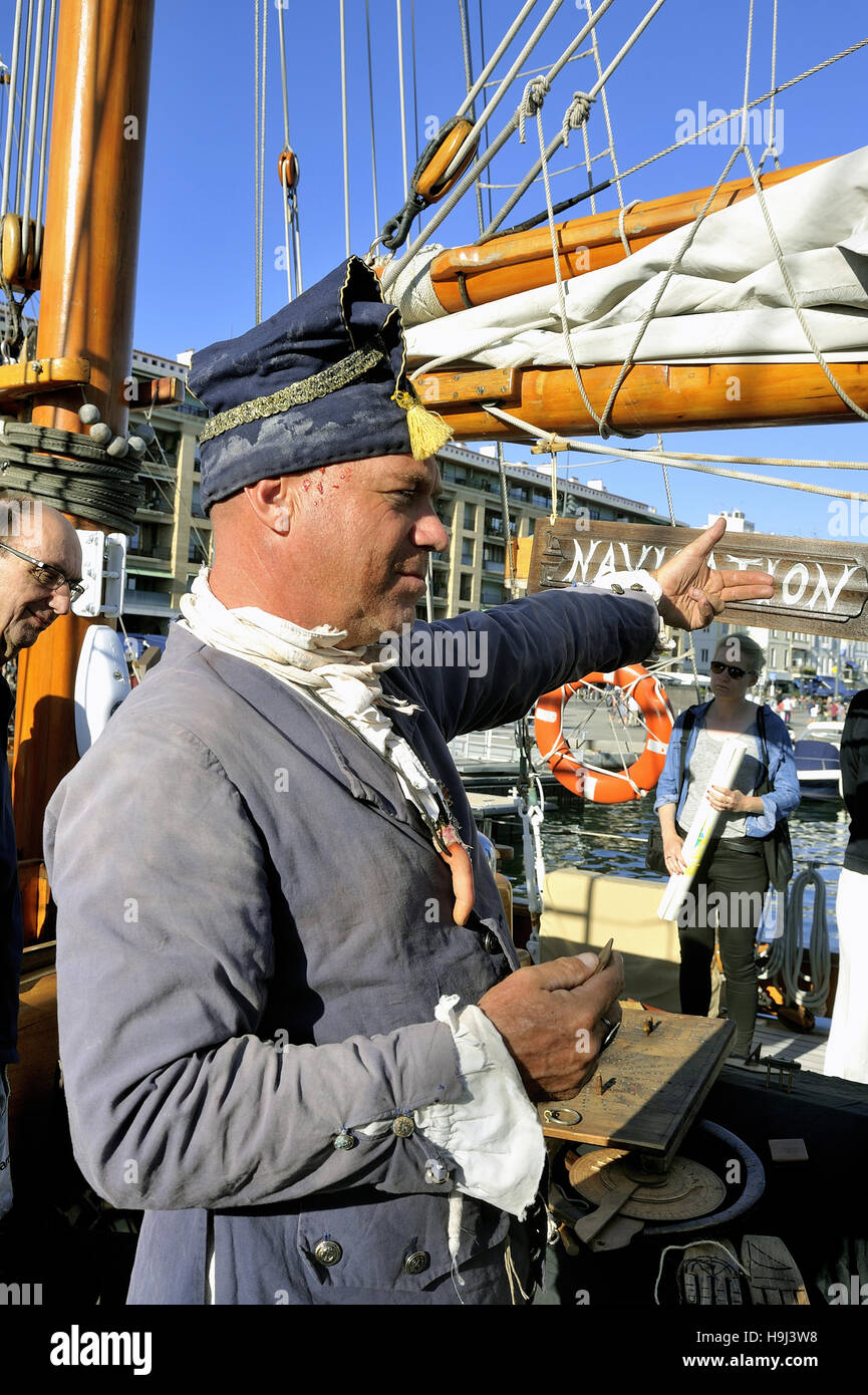 Sailor decorated with ancient garment on an old sailboat to explain to ...