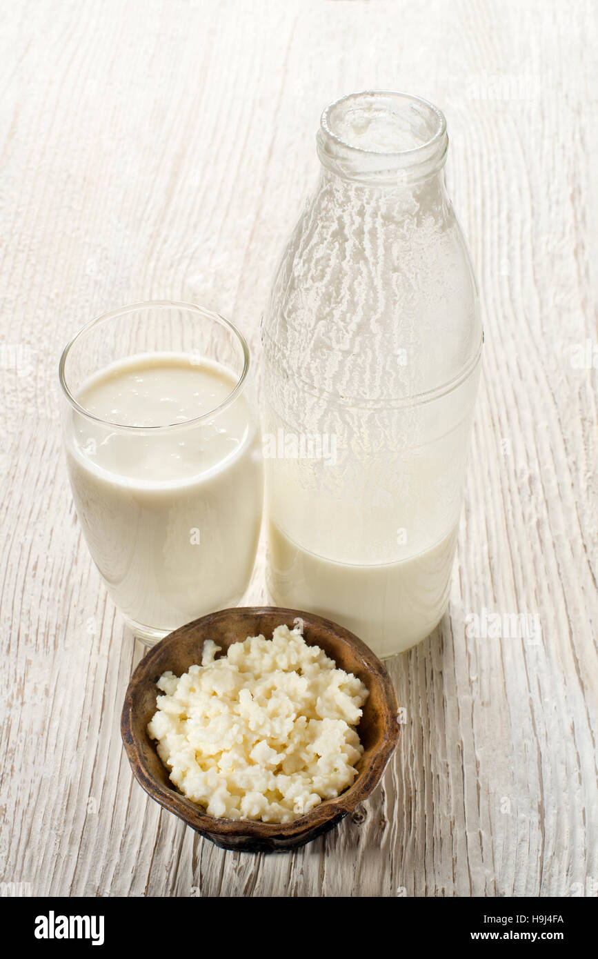 Milk kefir and grains in glass on wooden table Stock Photo - Alamy