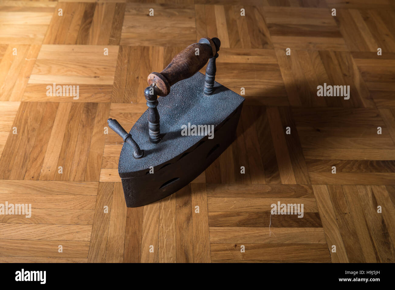 An old heavy iron standing on a wooden floor Stock Photo - Alamy
