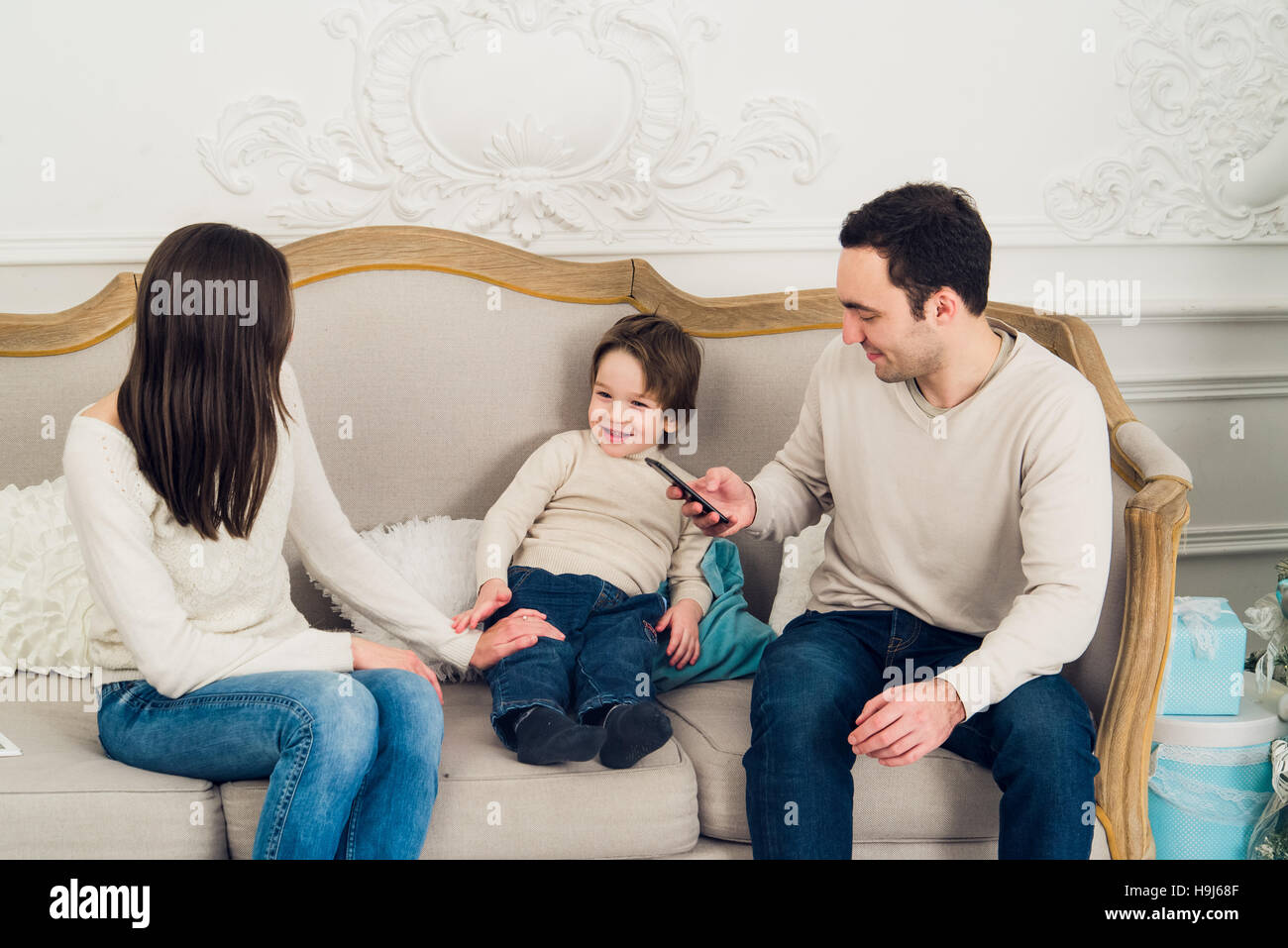 family phone talking - cute little boy, his mother and father are ...