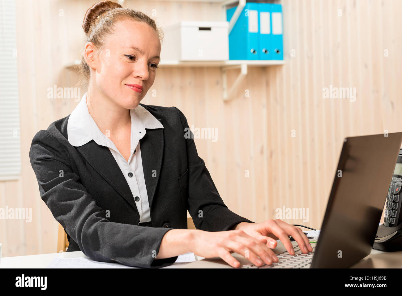 smiling pretty secretary typing text on your computer Stock Photo - Alamy