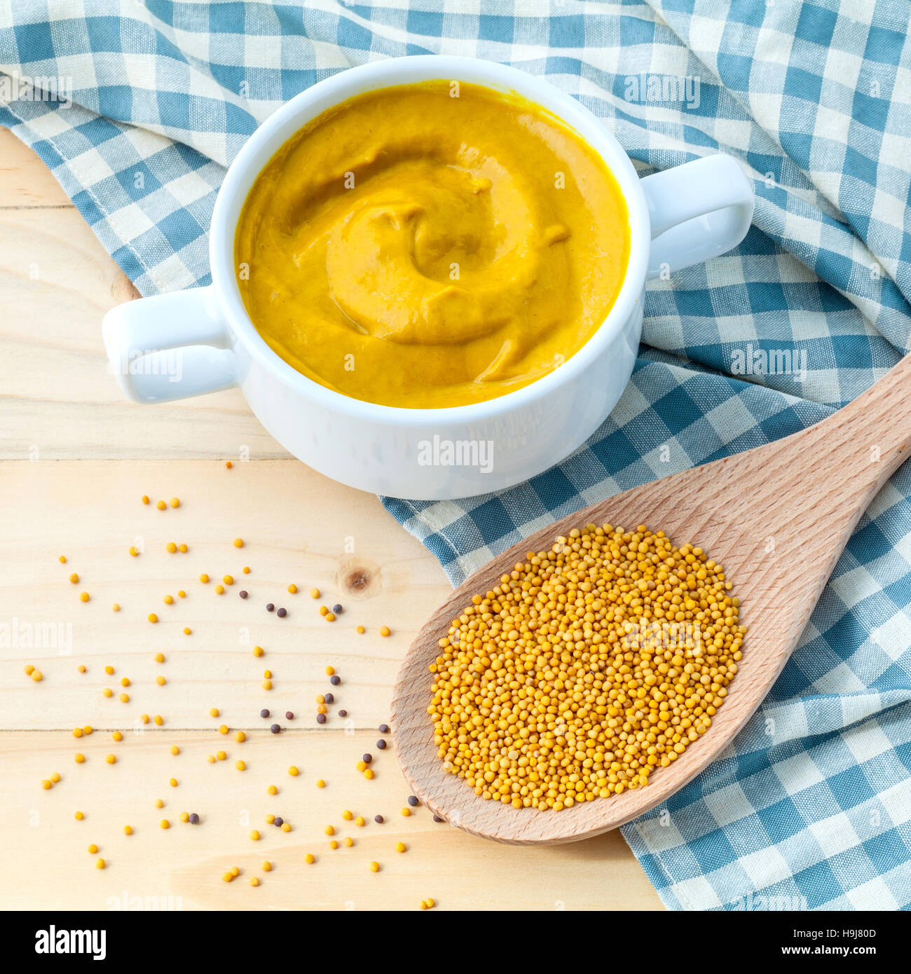 Composition of mustard and mustard seeds on wooden background Stock ...