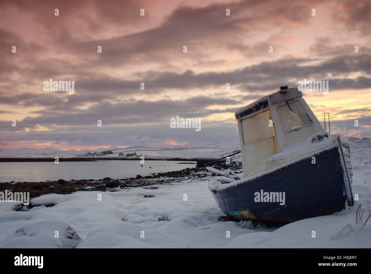 A fishing boat sits on a snow covered bay Stock Photo - Alamy