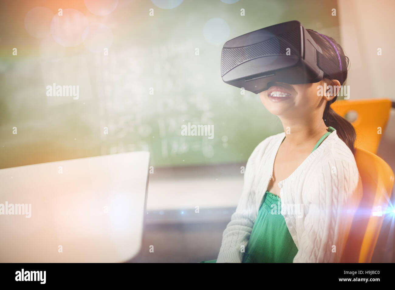 Seated girl wearing virtual reality glasses Stock Photo - Alamy