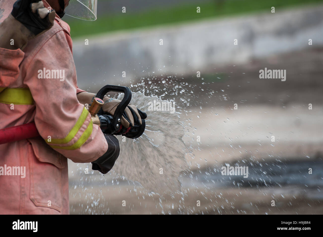 Firefighters spray water Stock Photo - Alamy