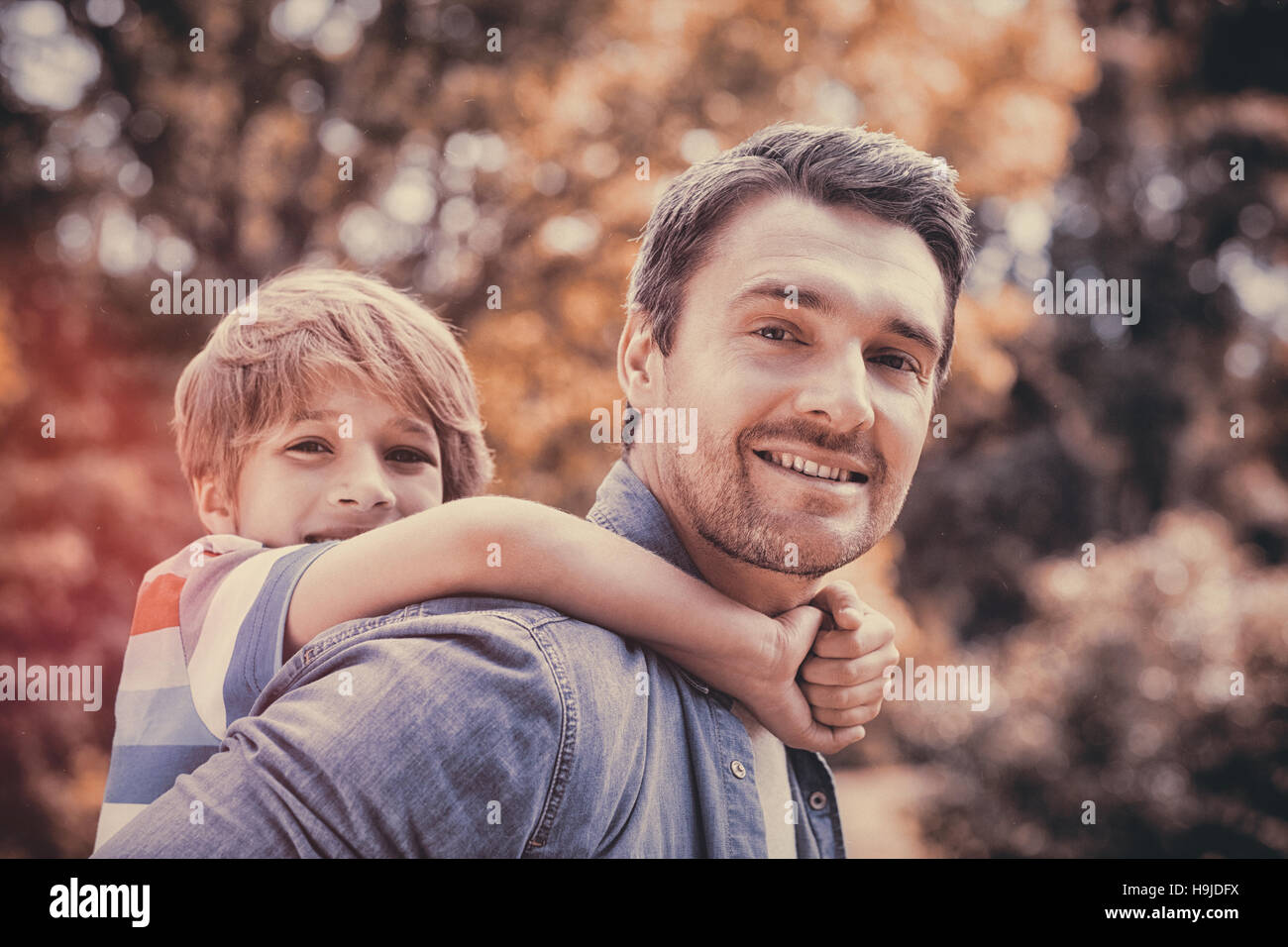 Father carrying young boy on back at park Stock Photo - Alamy