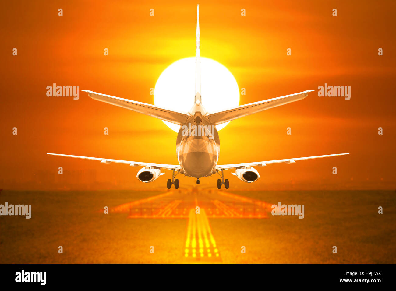 Rear view passenger aircraft takeoff on runway in sunset Stock Photo ...