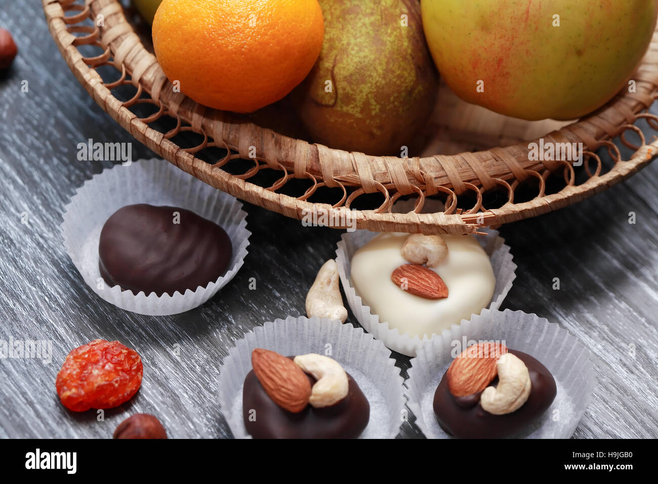 Few chocolate candies and nuts on wooden table Stock Photo - Alamy