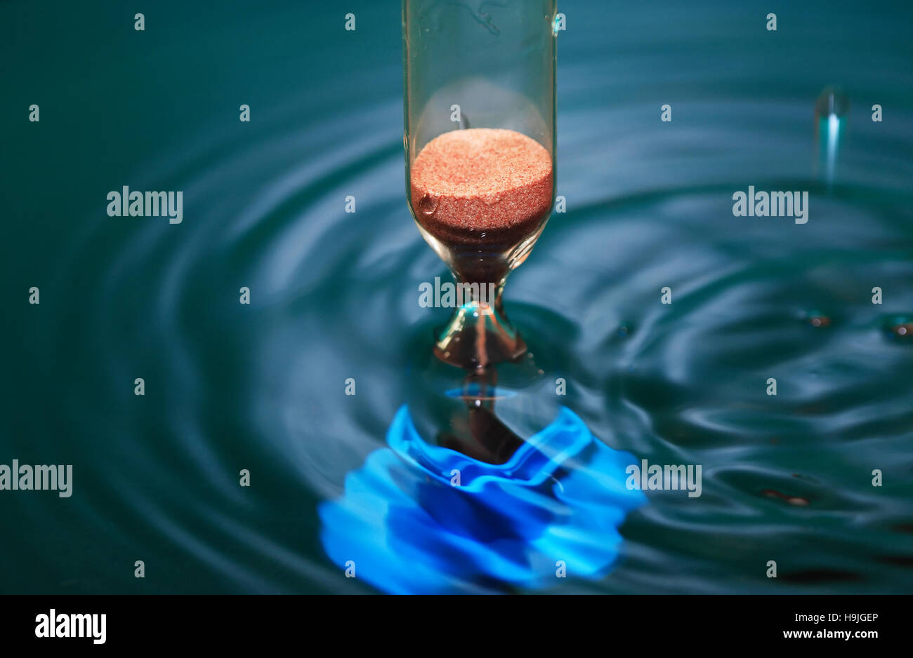 Flow time. Hourglass in dark splashing water Stock Photo - Alamy