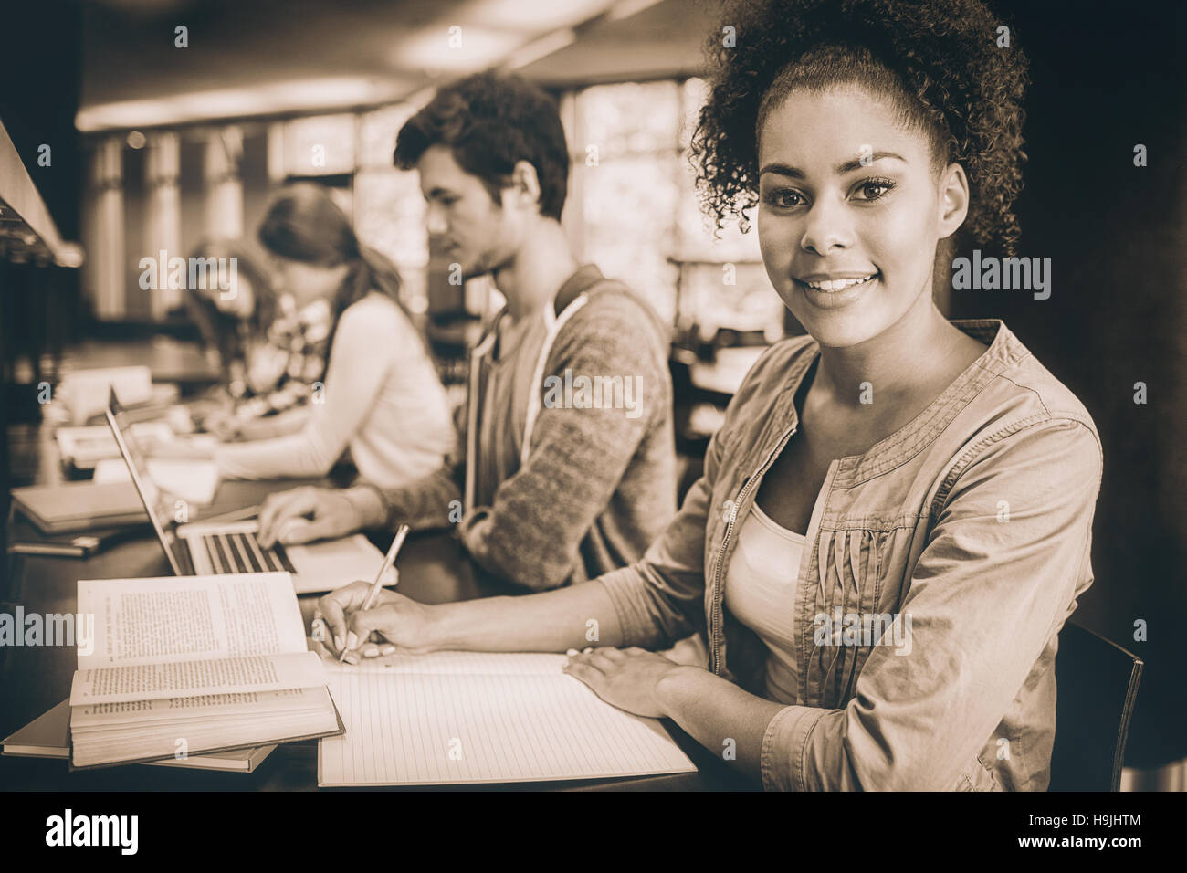 Student looking at camera while studying with classmates Stock Photo ...
