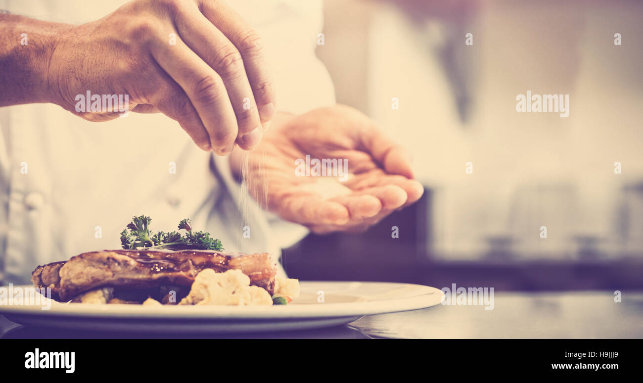Closeup mid section of a chef putting salt Stock Photo - Alamy