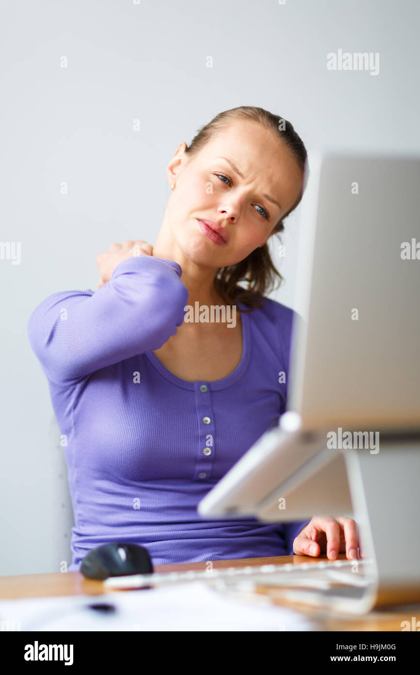 Working too hard - young woman working on a computer at an office ...