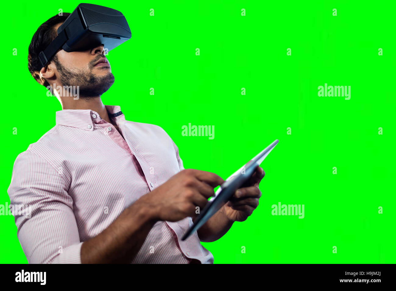 Composite image of man using an oculus and a tablet Stock Photo - Alamy