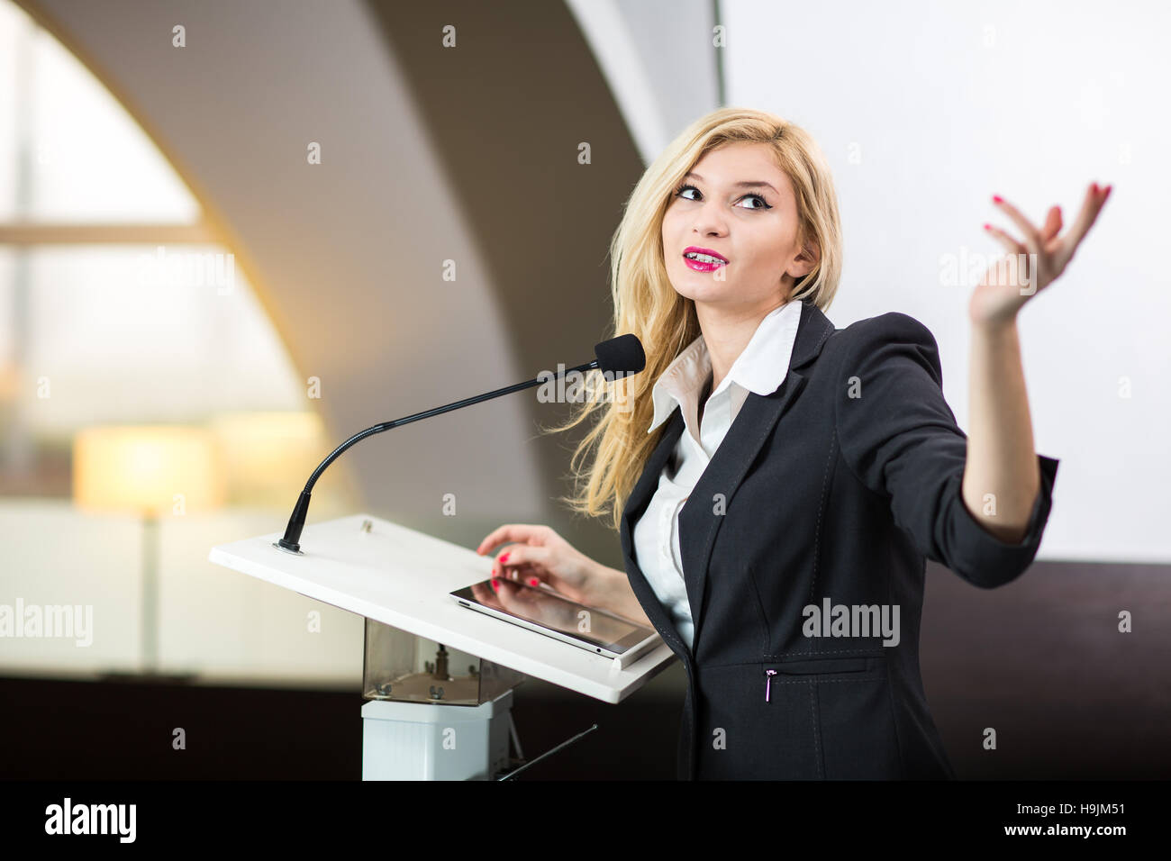 Pretty, young business woman giving a presentation in a conference ...