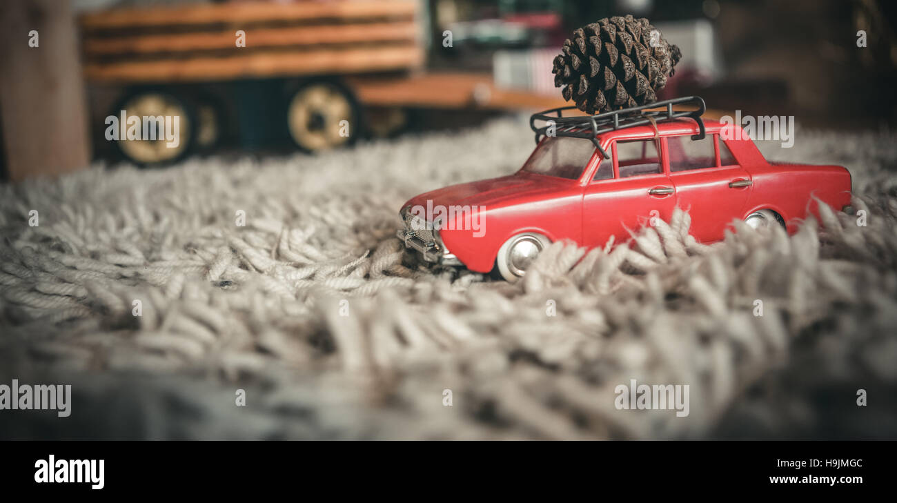 Toy car carrying christmas pine cone Stock Photo - Alamy