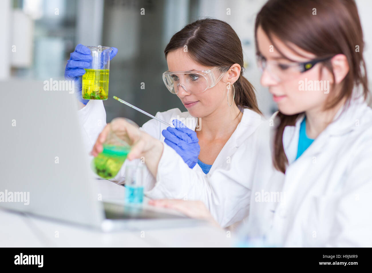 Two young female researchers carrying out experiments in a lab (shallow ...