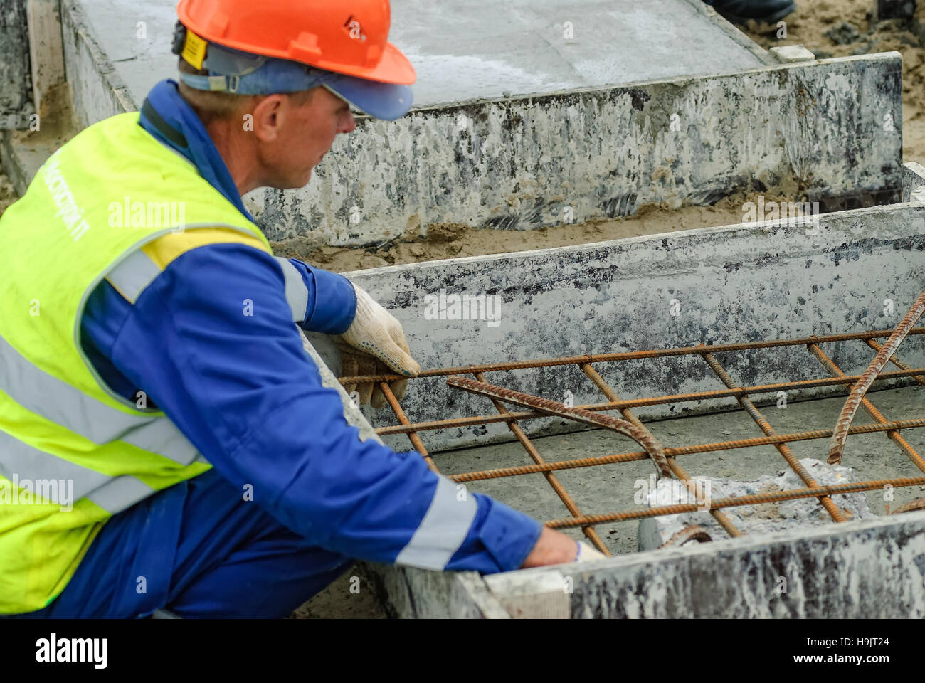 Worker makes base for big oil tank Stock Photo - Alamy