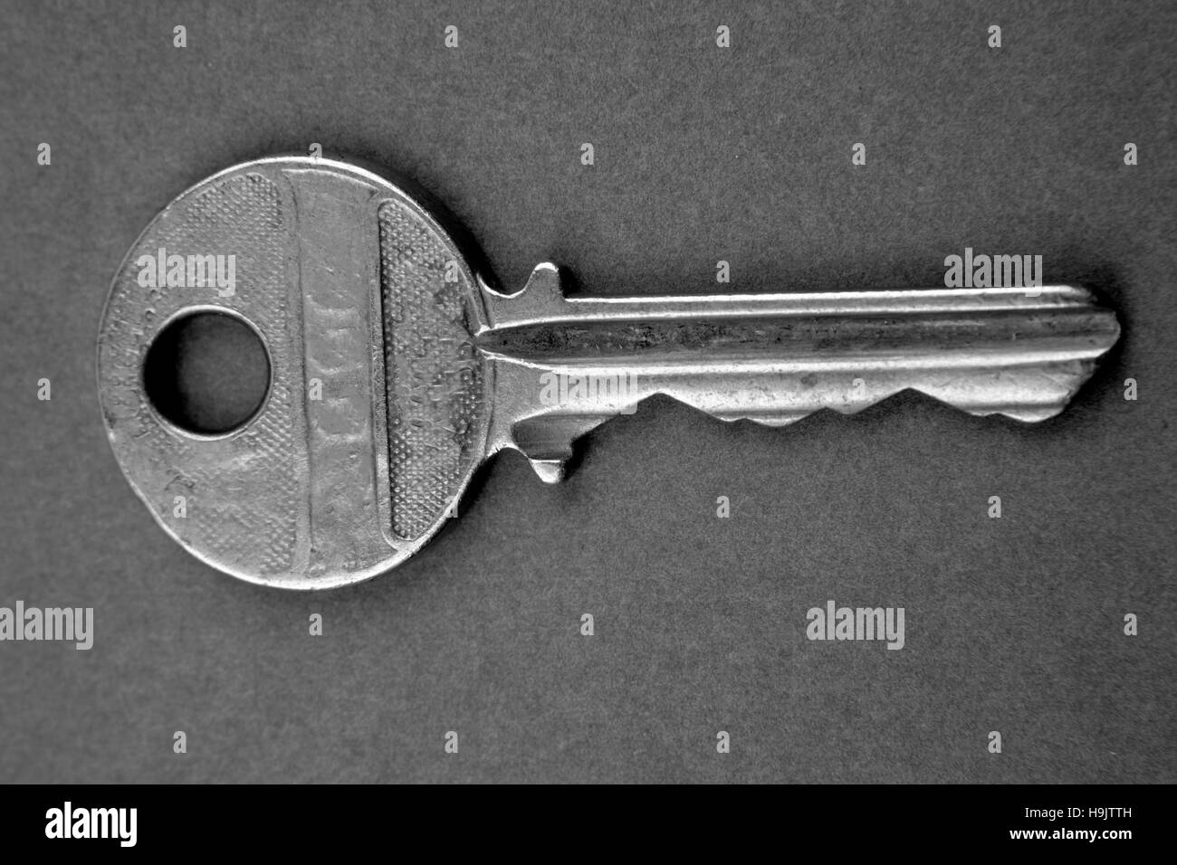 Closeup of single key on gray background Stock Photo - Alamy