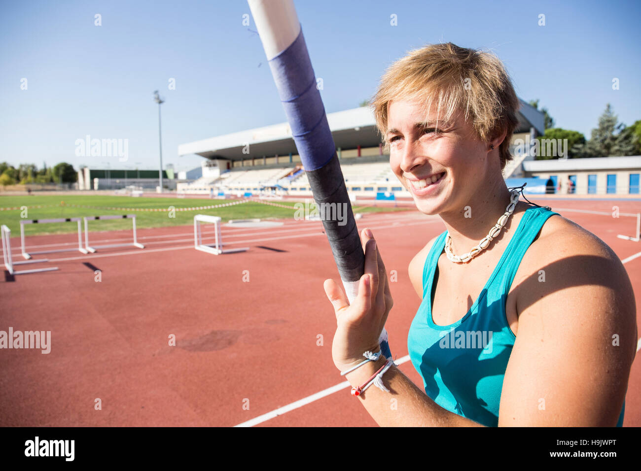 Smiling female pole vaulter preparing Stock Photo - Alamy