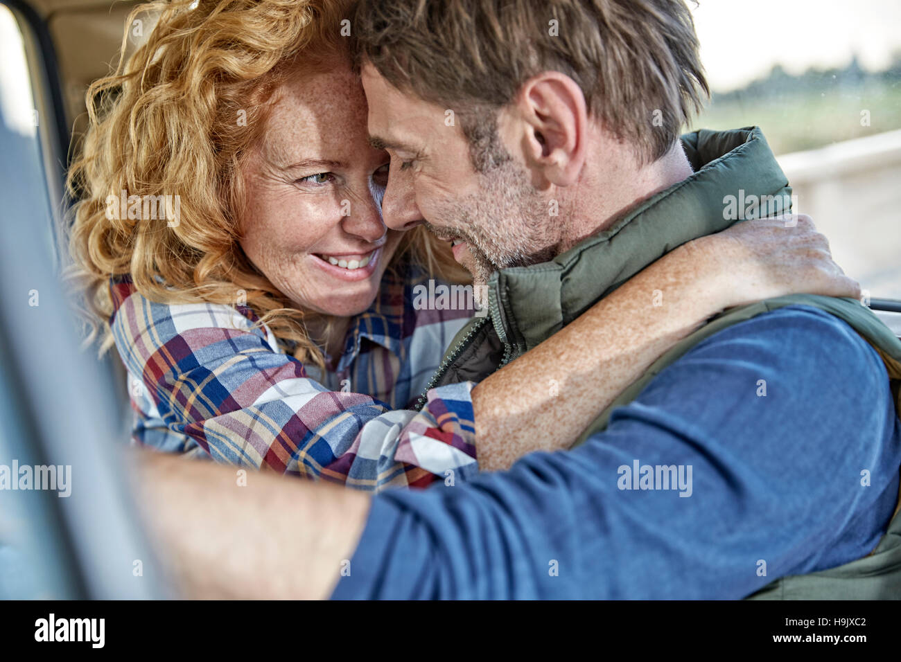 Happy couple hugging in car Stock Photo - Alamy