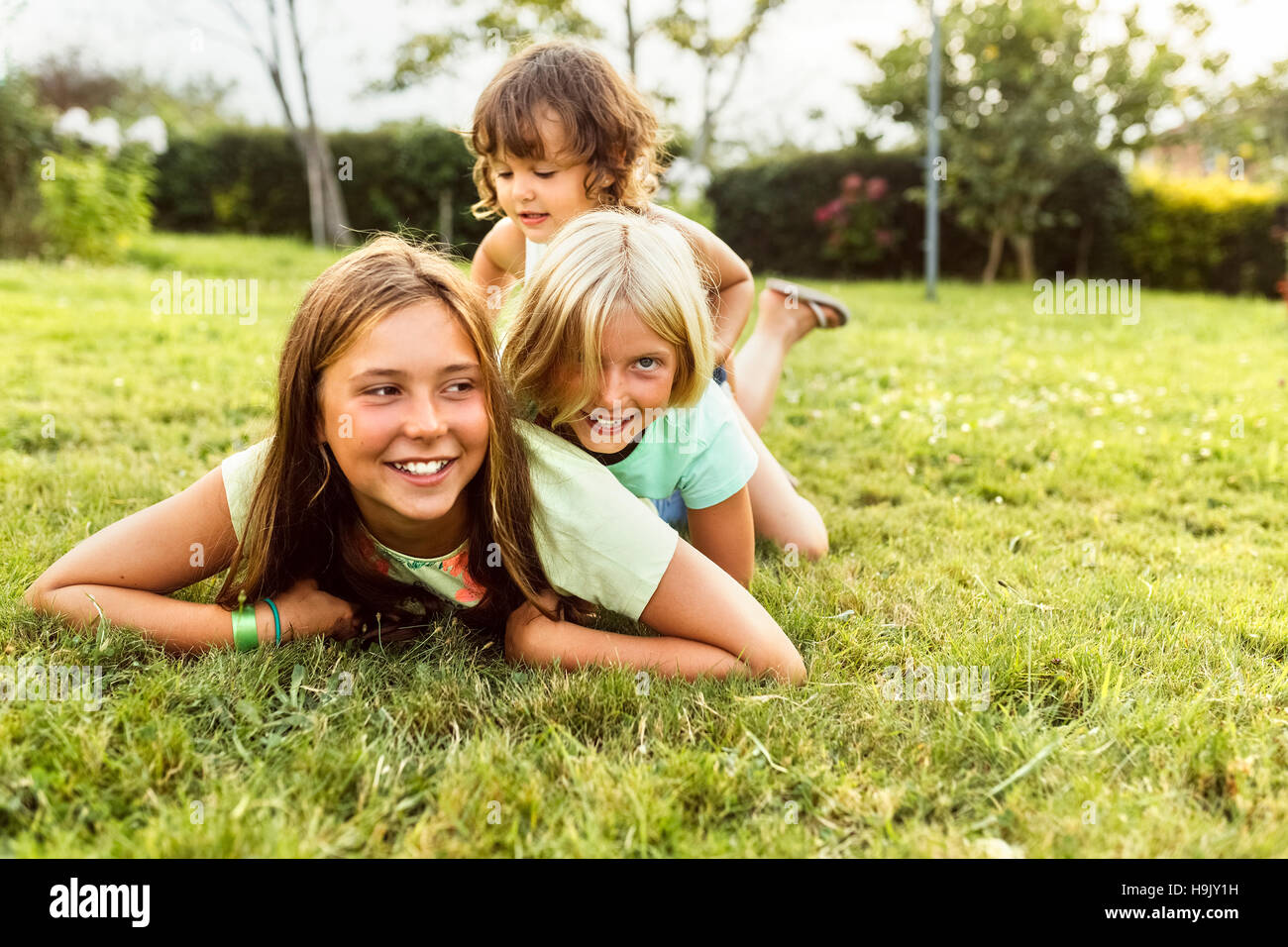 Three girls having fun together on a meadow Stock Photo - Alamy