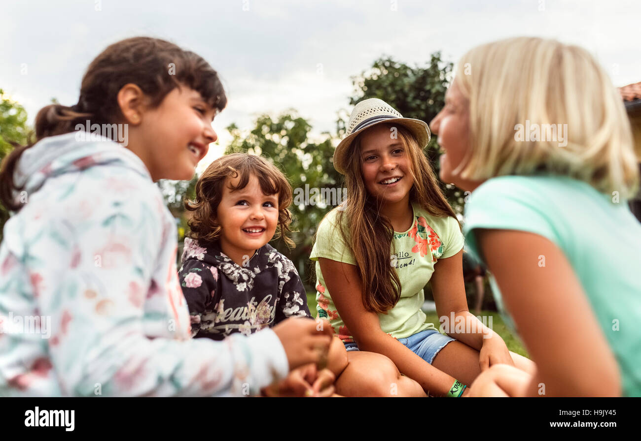 Four girls talking together on a meadow Stock Photo - Alamy