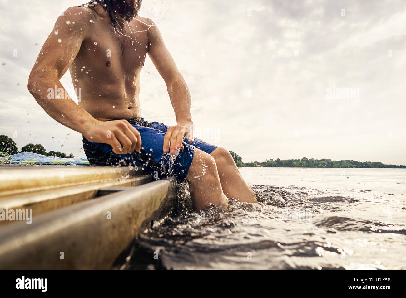 Man getting out of water on jetty Stock Photo - Alamy