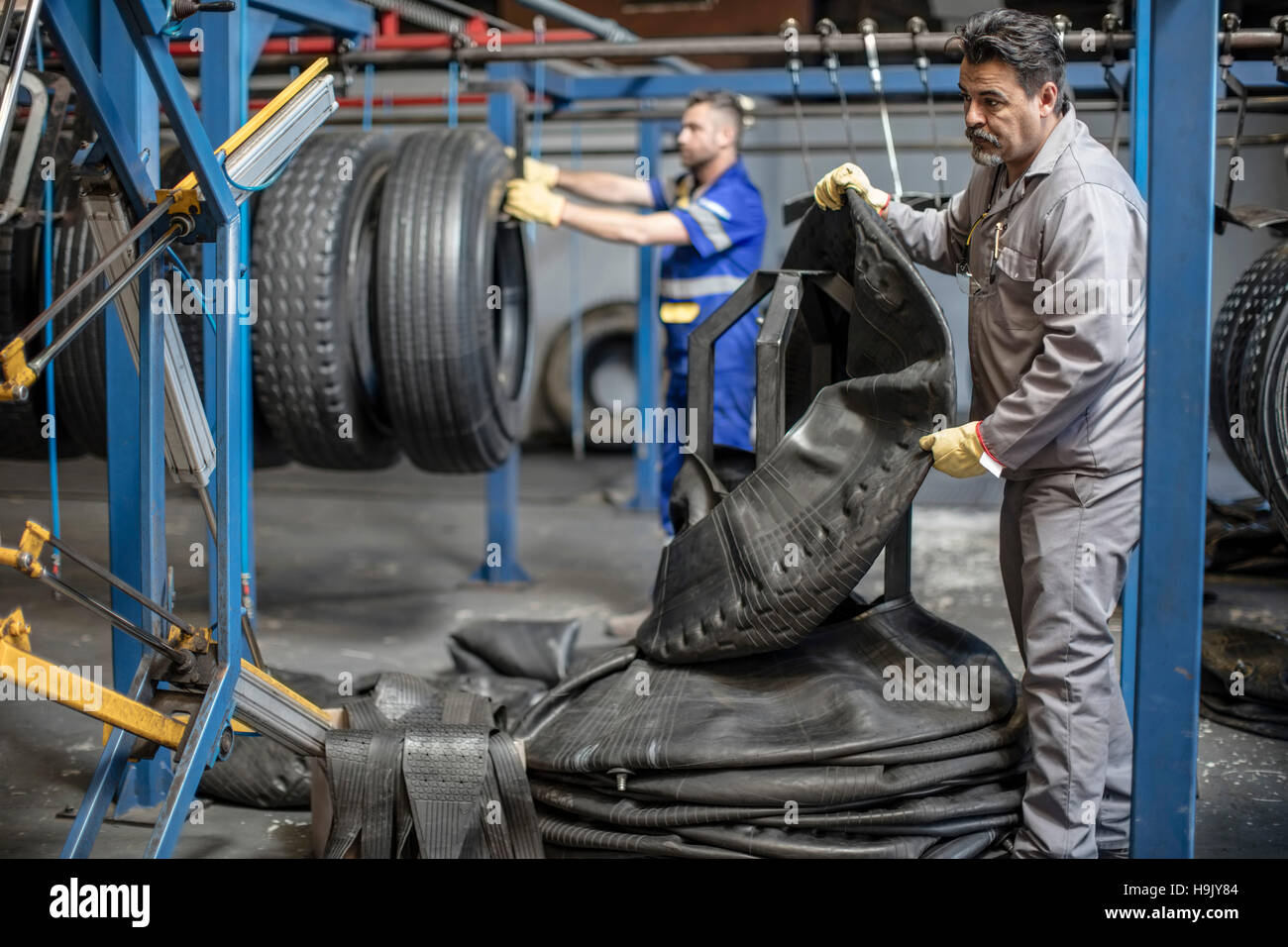 Two tire repairmen working in factory Stock Photo - Alamy