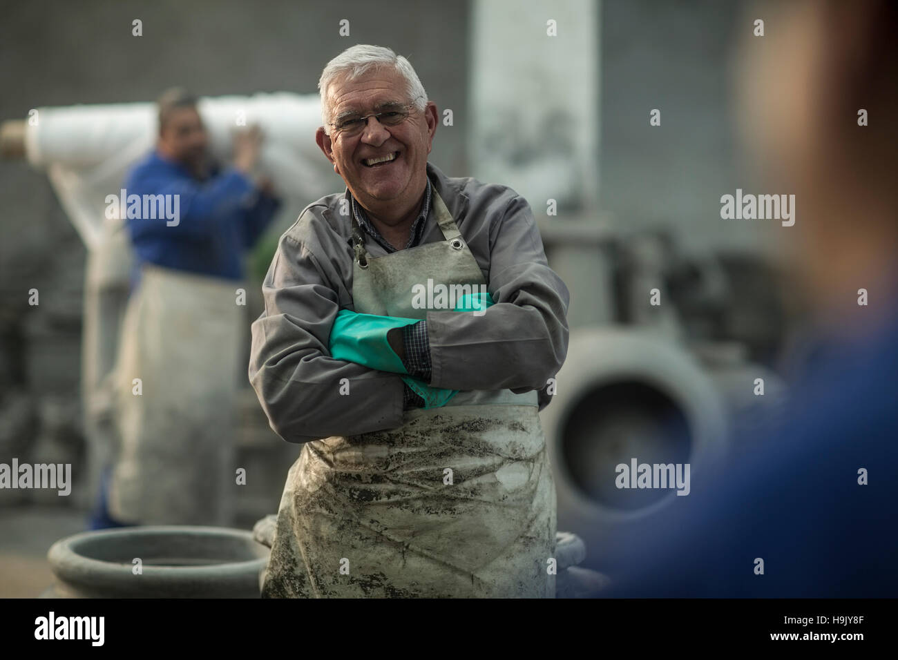 Portrait of smiling worker in industrial pot factory Stock Photo - Alamy