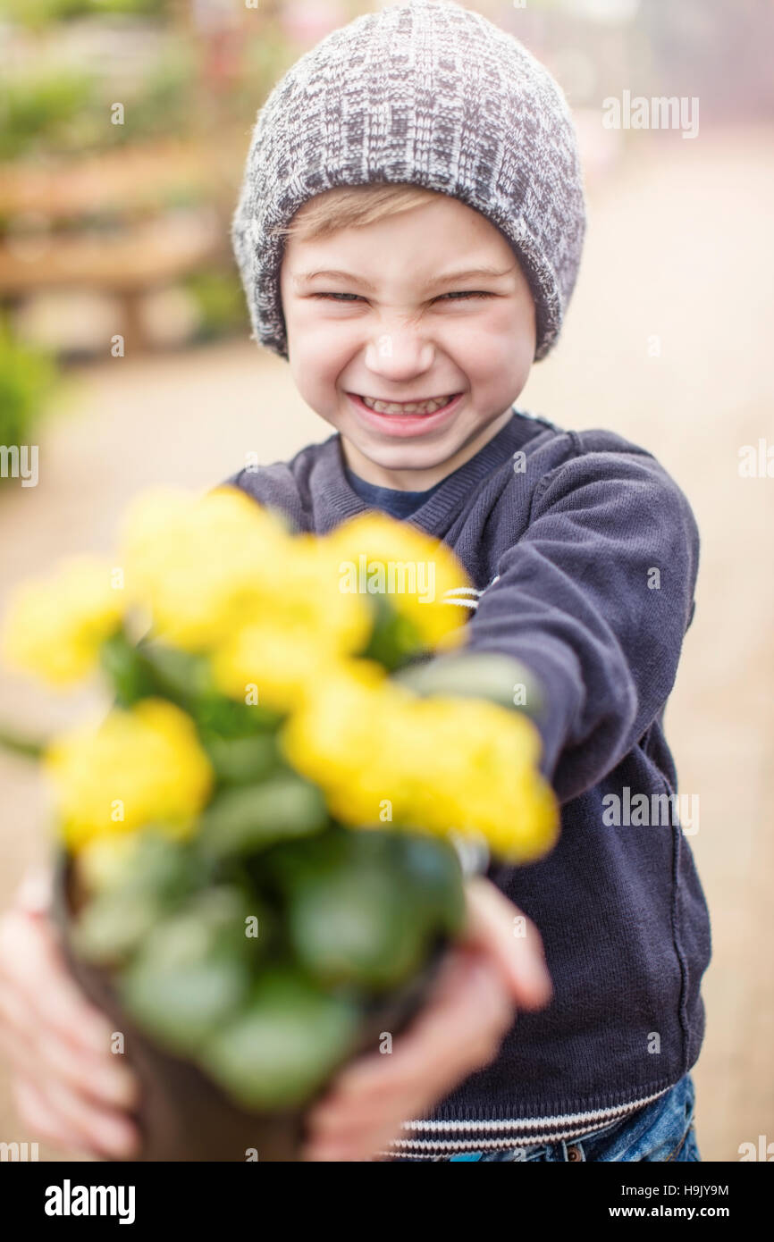 Boy holding yellow flower pot Stock Photo - Alamy
