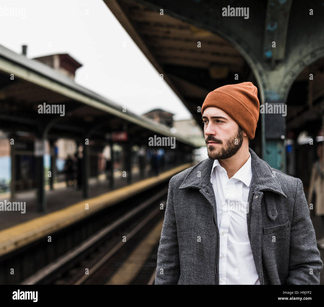 Young man waiting at metro station platform Stock Photo - Alamy