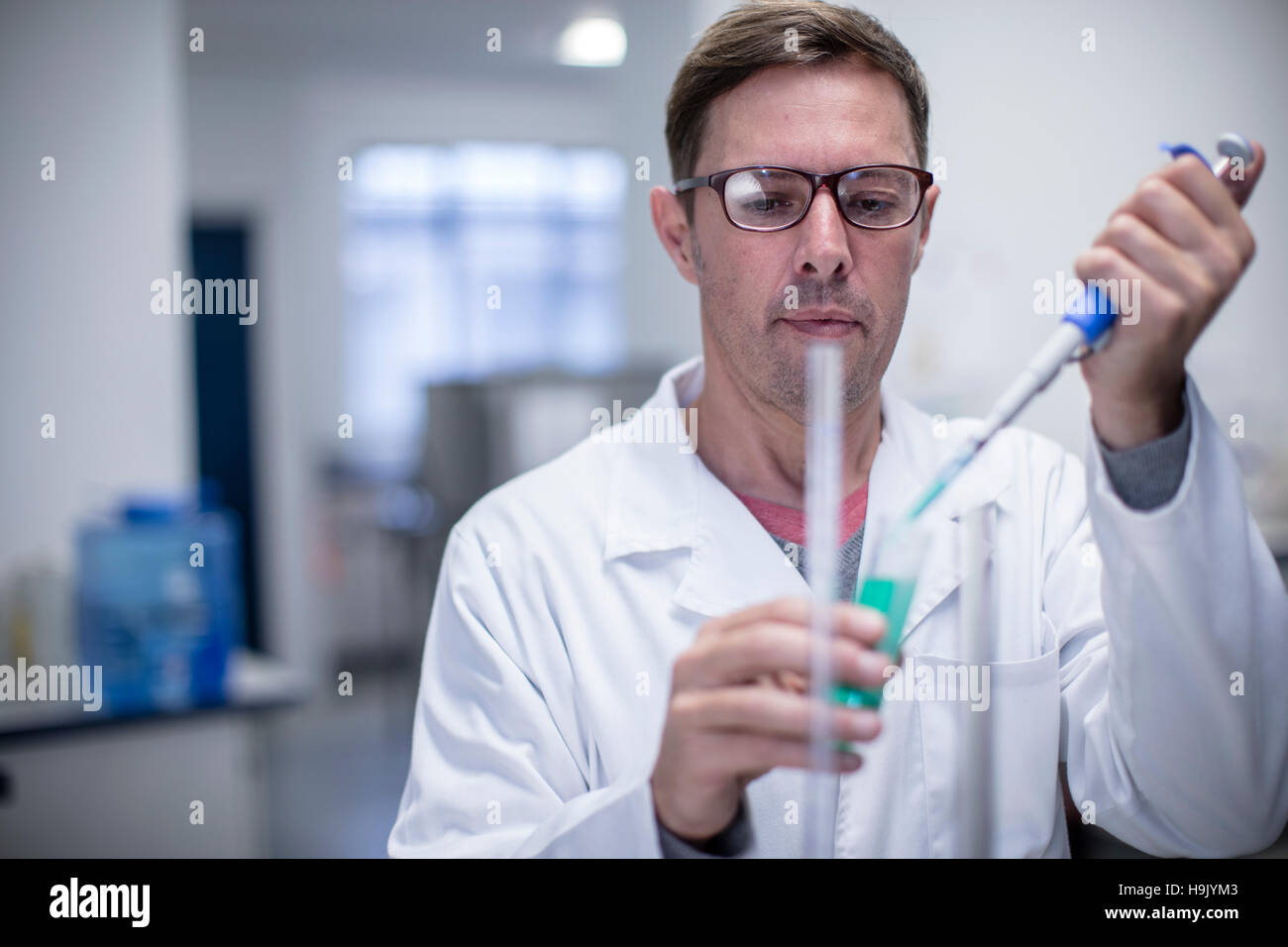 Scientist pipetting in lab Stock Photo - Alamy