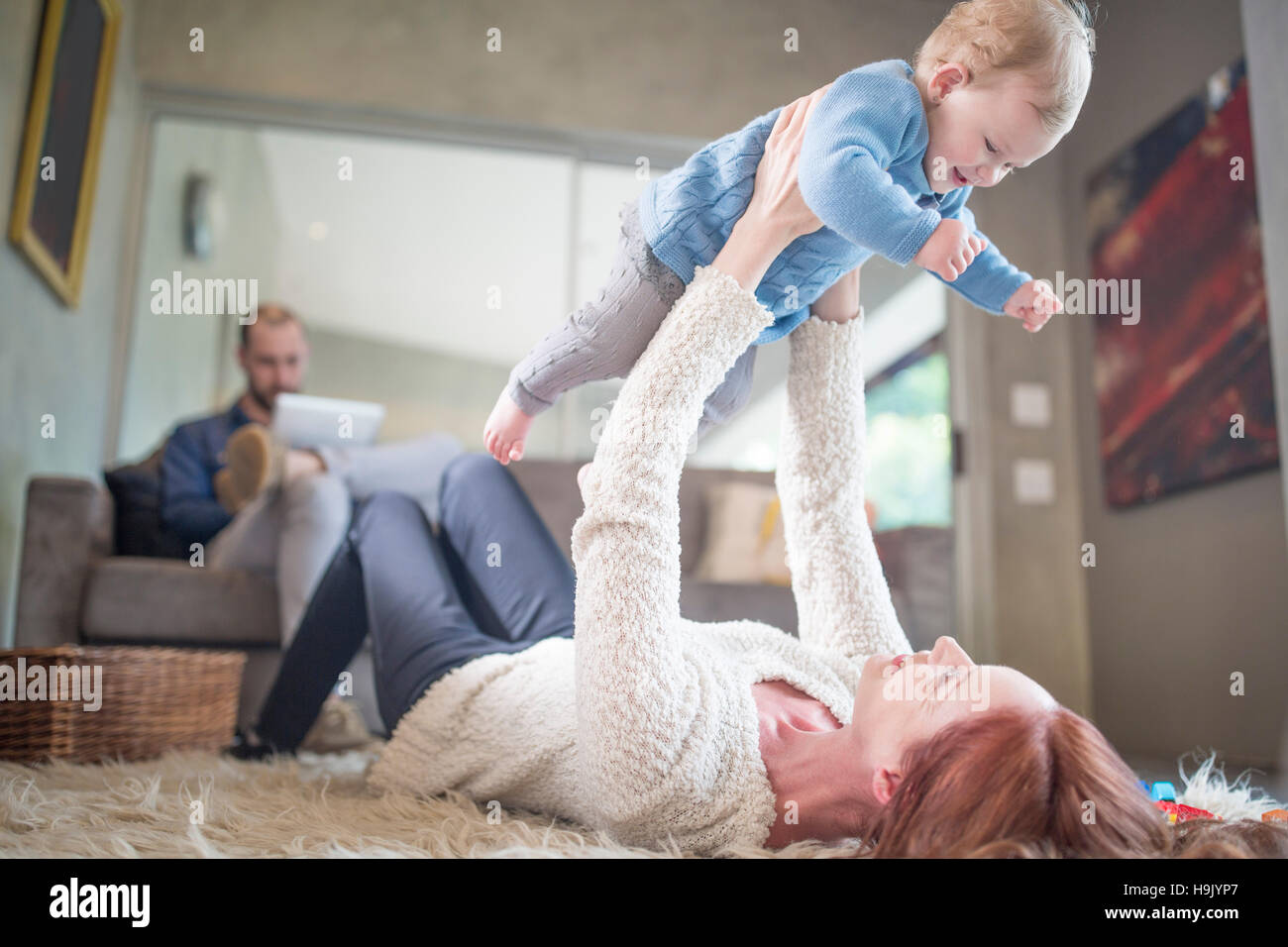 Mother lifting baby girl at home Stock Photo - Alamy