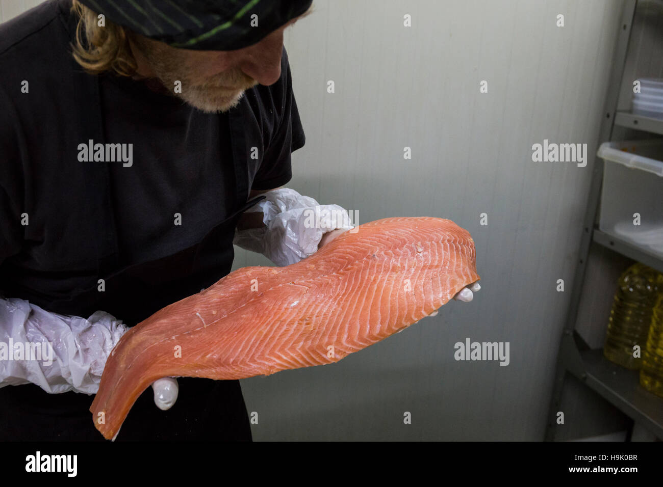Man looking at freshly smoked salmon steak in a smokehouse Stock Photo ...