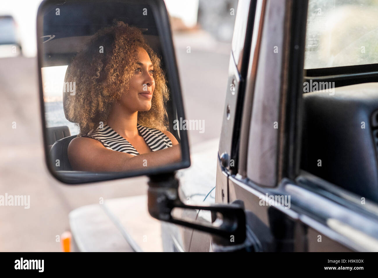 Mirror image of smiling young car driver Stock Photo - Alamy