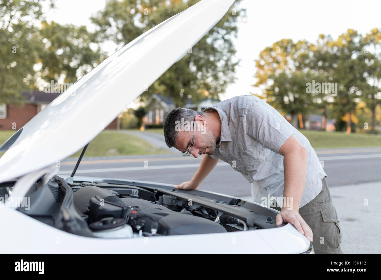 Man checking his car standing at the road side Stock Photo - Alamy