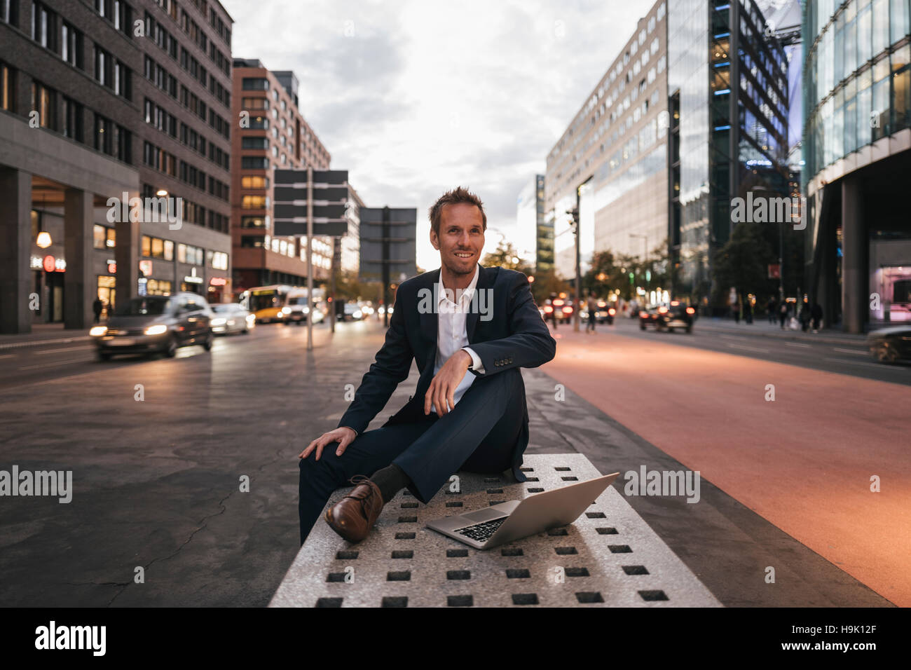 Germany, Berlin, Potsdamer Platz, businessman sitting on bench with ...